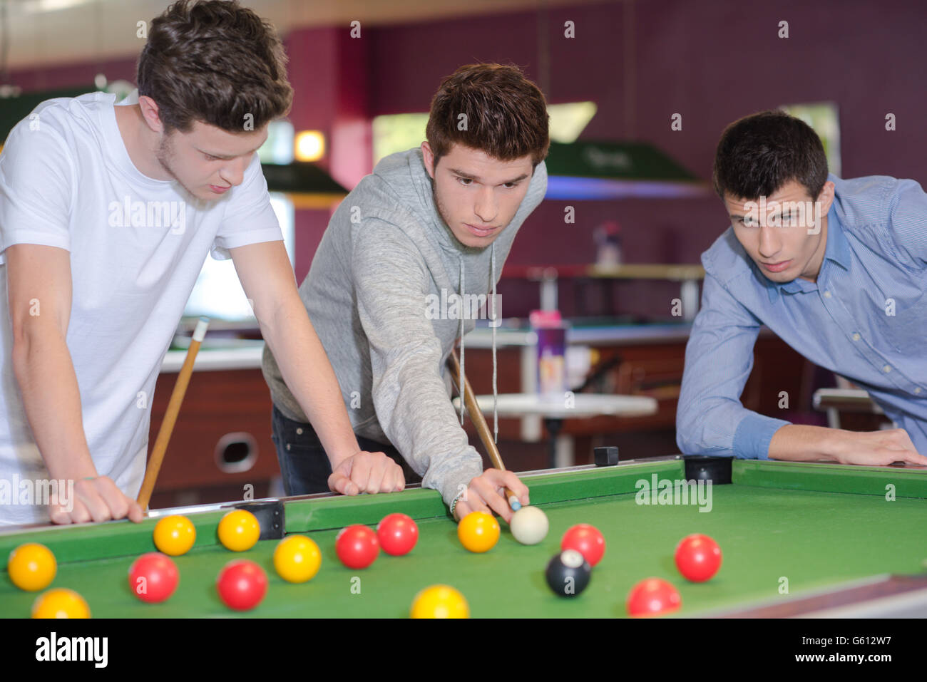 Three men around the pool table Stock Photo - Alamy