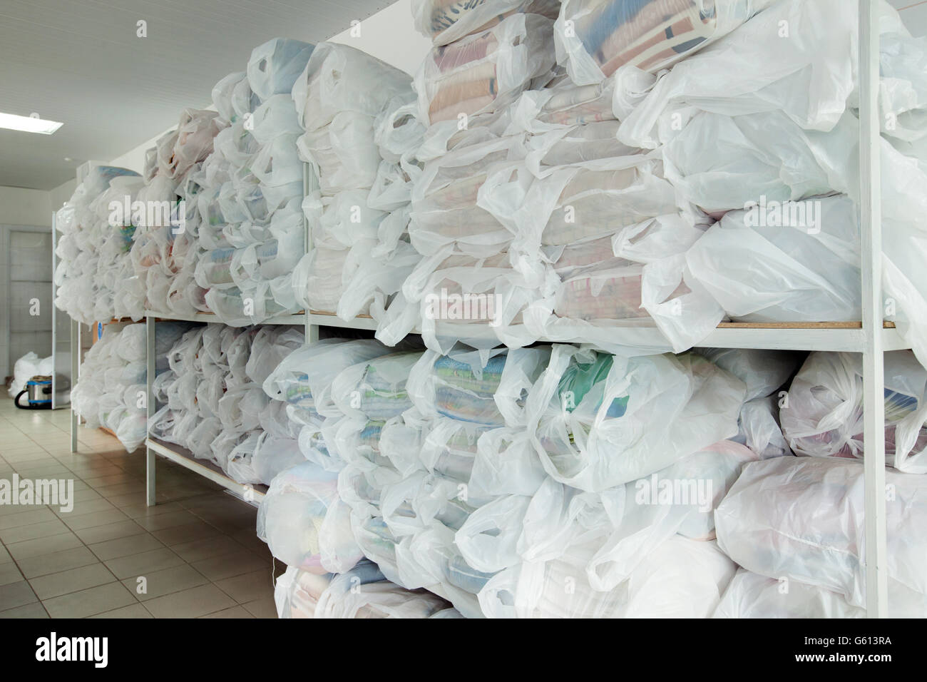Racks with clean linen in laundry room Stock Photo - Alamy