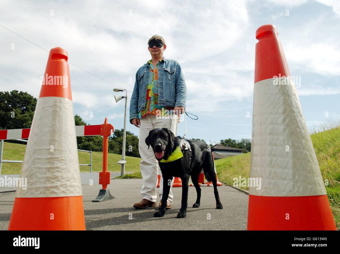 Actor Martin Clunes is led around an obstacle course by Buster the ...