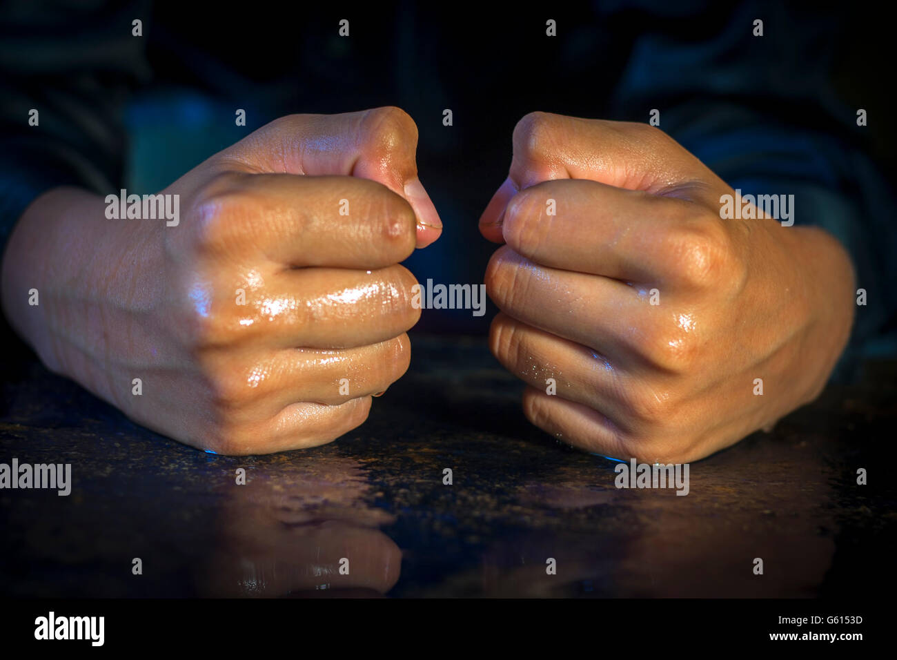 Wet Human fists on the rough surface, black background Stock Photo - Alamy