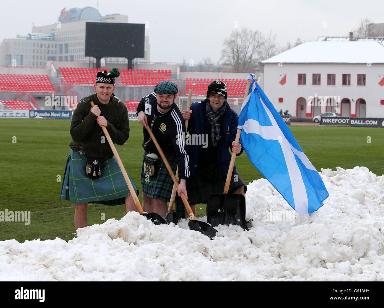 Scotland fan Dougie McKinlay (c) with his friends helping to clear snow ...