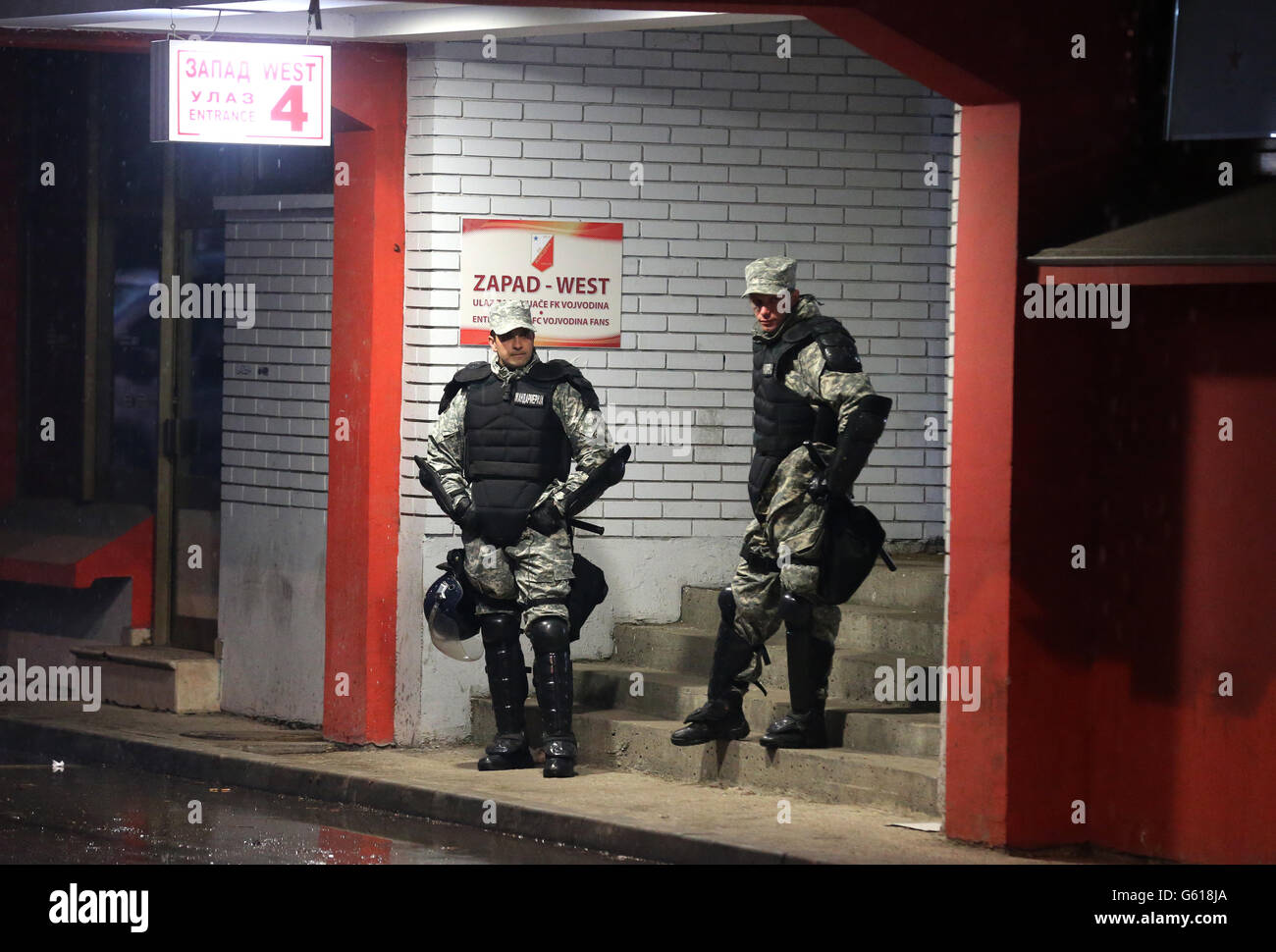 Police officers shelter from the rain outside the stadium before the ...