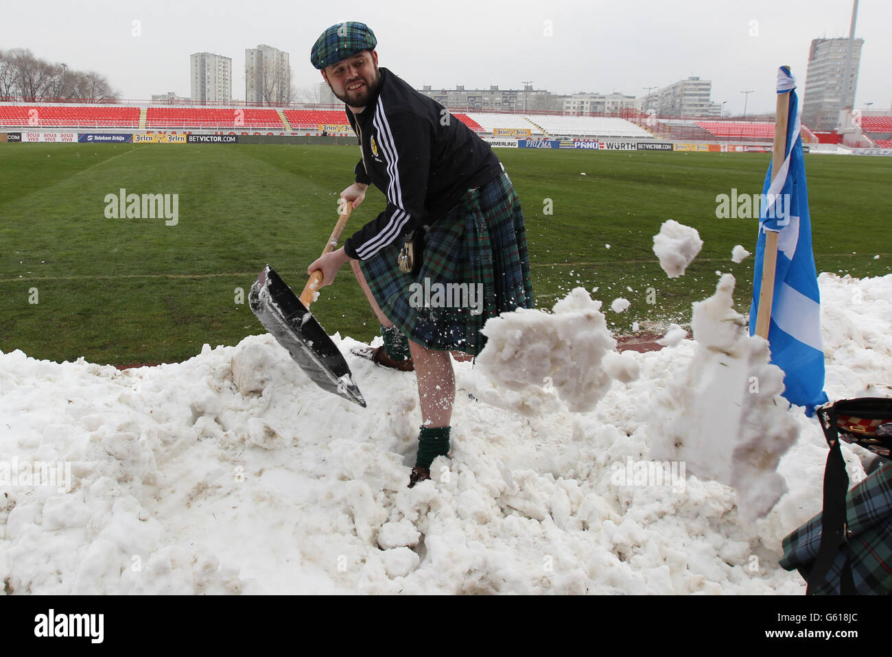 Scotland fan Dougie McKinlay helping to clear snow from the pitch in ...