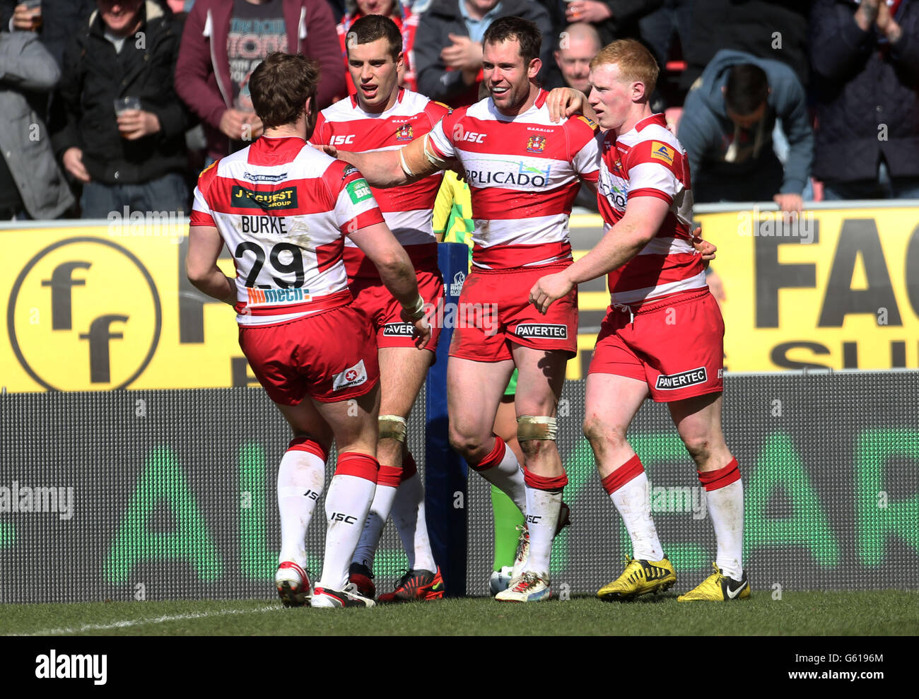 Wigan's Pat Richards (centre) celebrates his second try with Greg Burke ...