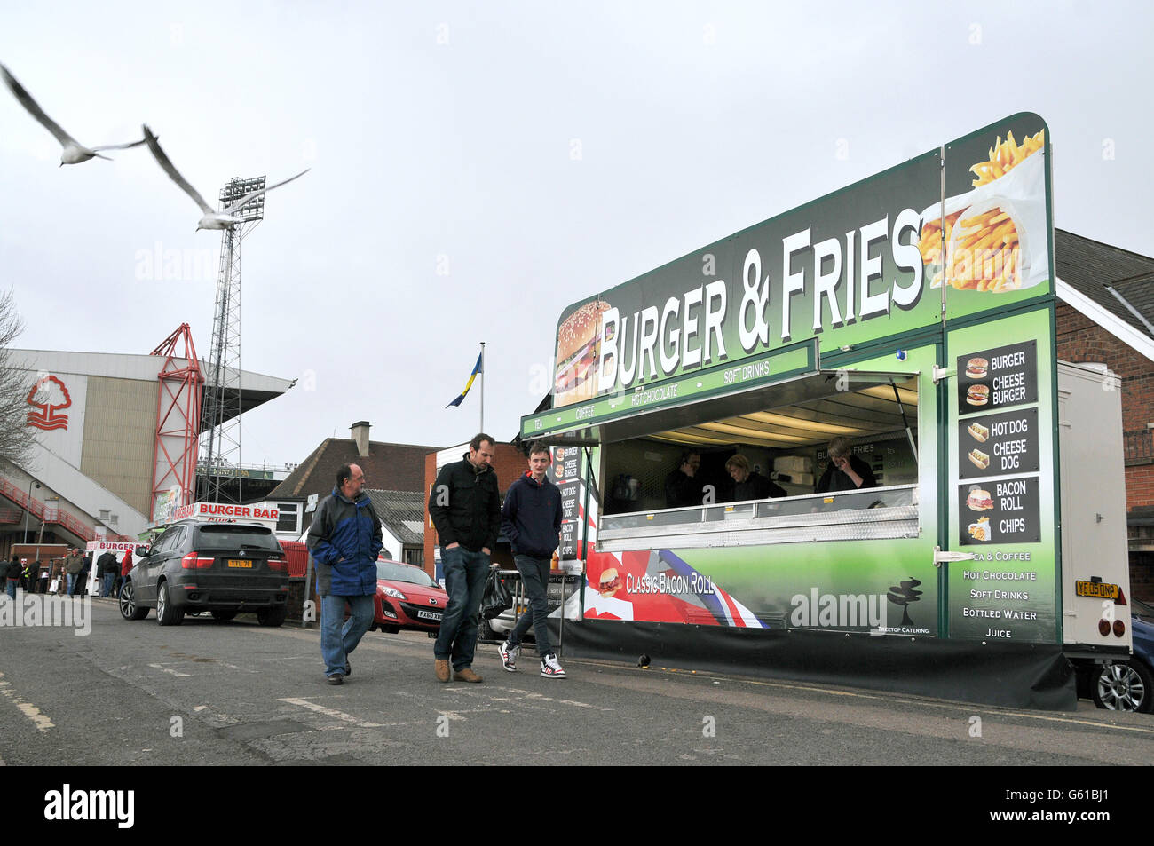 Fans walk past a burger van outside the City Ground before the game ...
