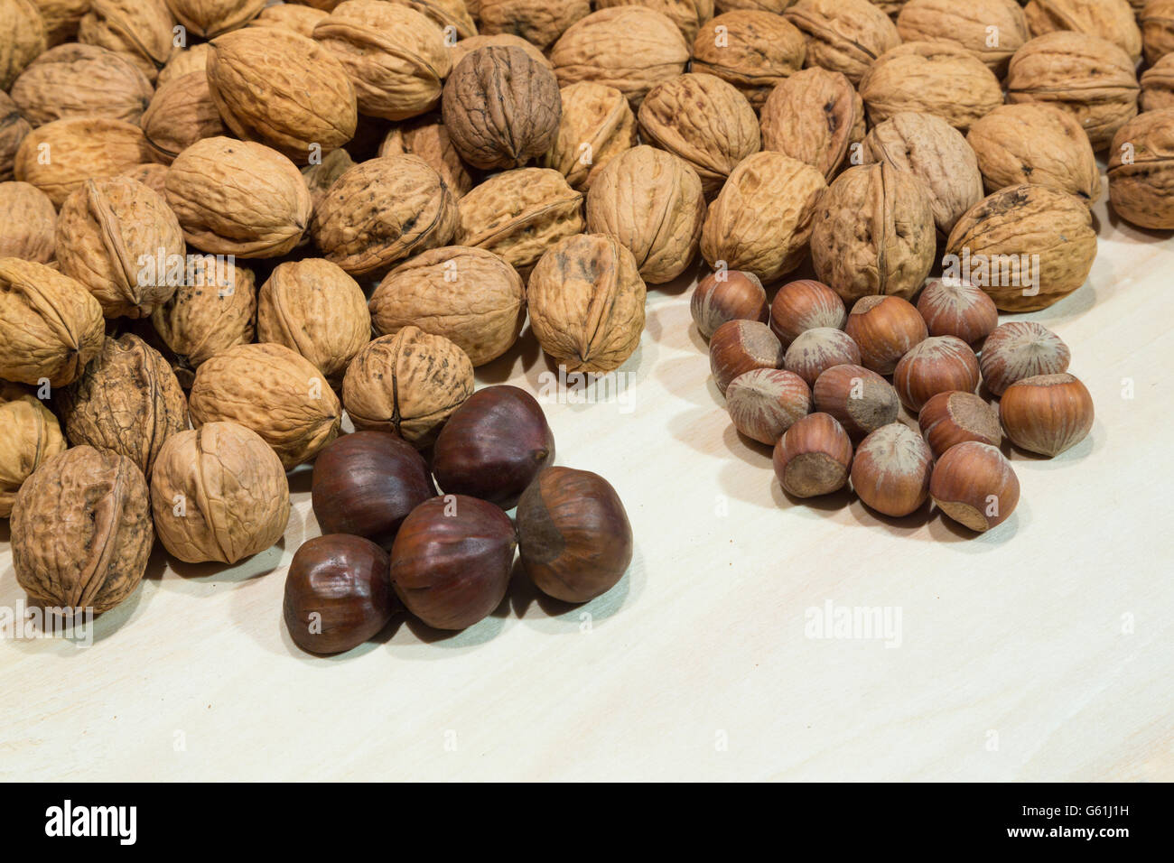 Walnuts, chestnuts and hazelnuts on a wooden table Stock Photo - Alamy