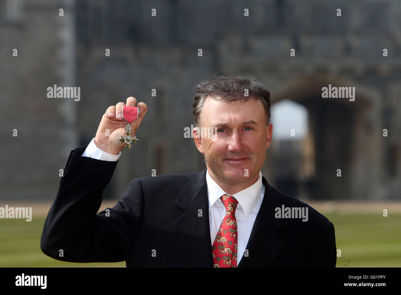 Peter Charles poses with his MBE after an Investiture ceremony at ...