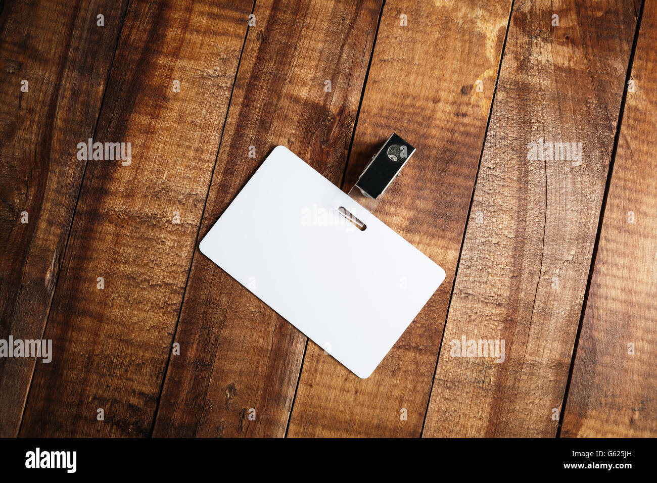 Blank plastic badge. Template for ID. Blank badge on wooden table ...