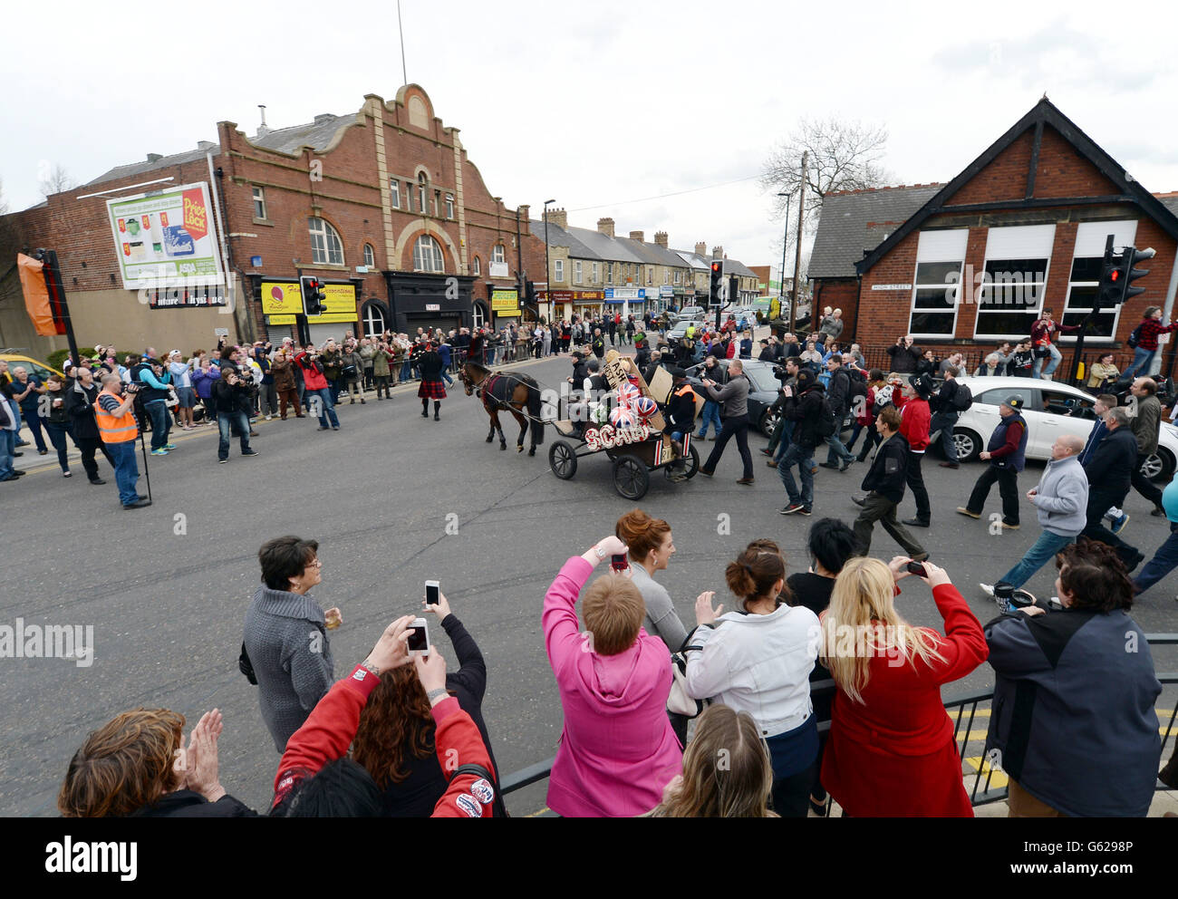 A coffin and effigy of Margaret Thatcher passes along the High Street ...