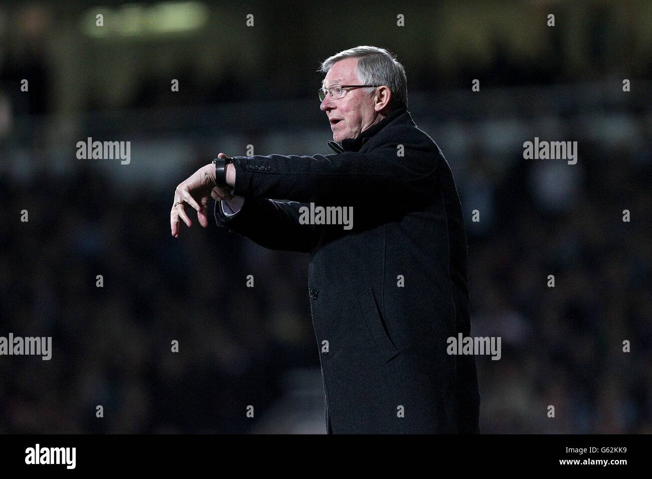 Manchester United manager Sir Alex Ferguson points to his watch on the ...