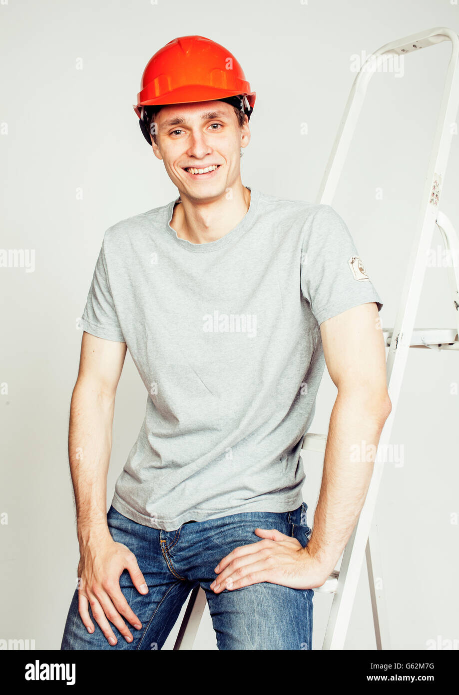 young real hard worker man isolated on white background on ladder ...