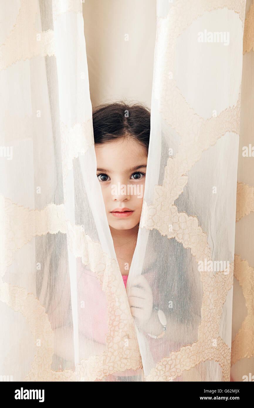 Little girl behind curtain Stock Photo - Alamy