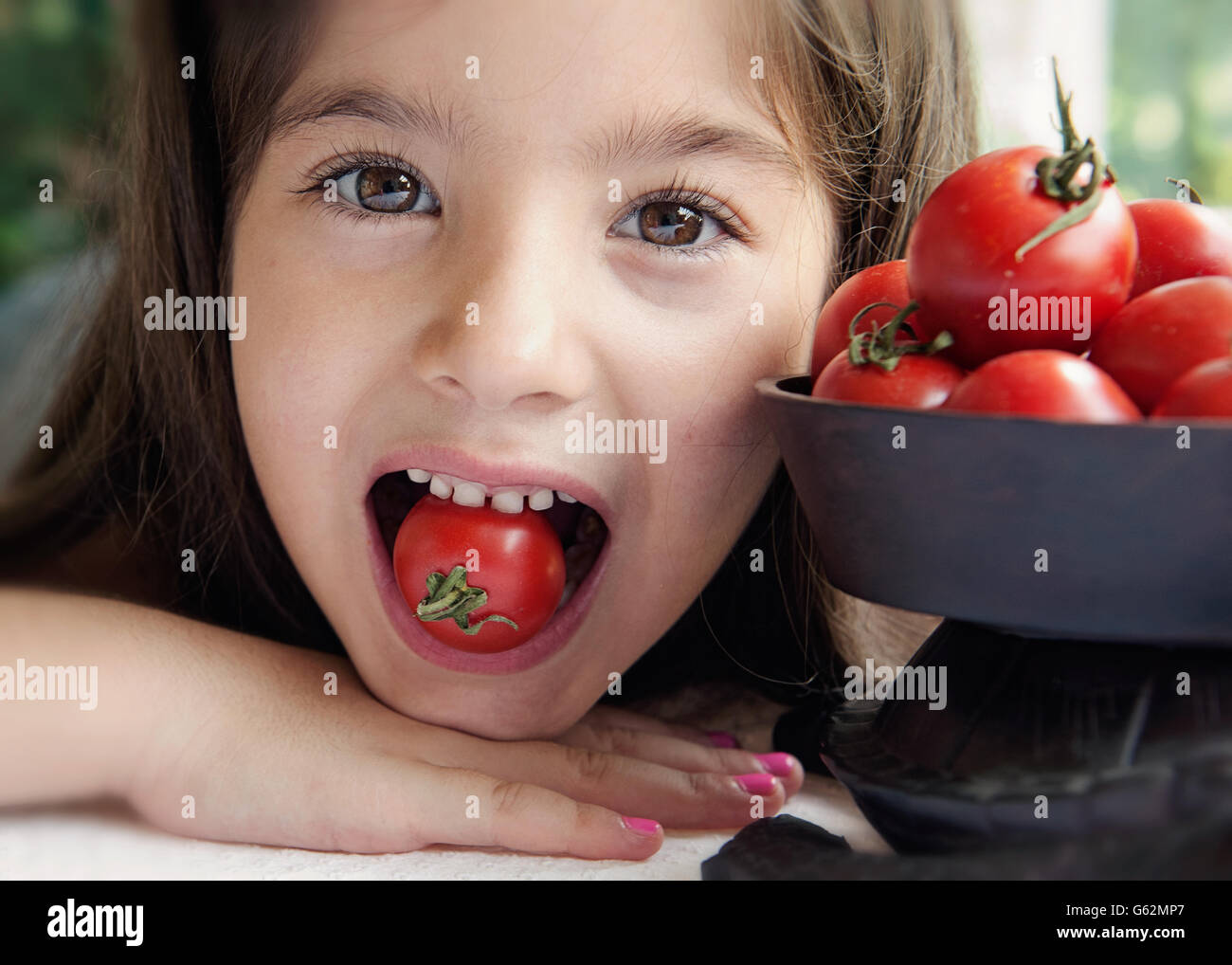 Girl biting cherry tomato, close up Stock Photo - Alamy