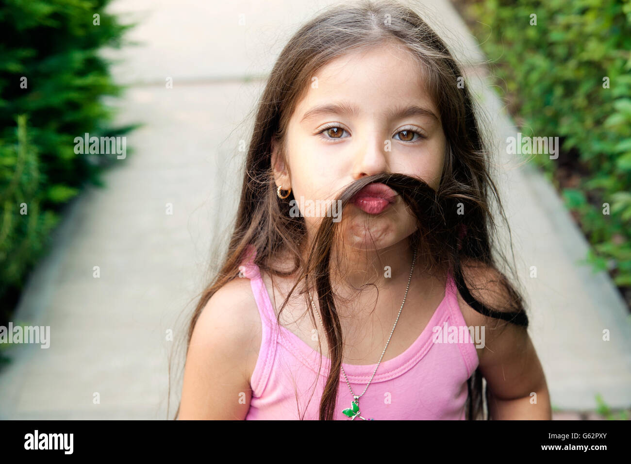 Little girl making a mustache with her hair Stock Photo - Alamy