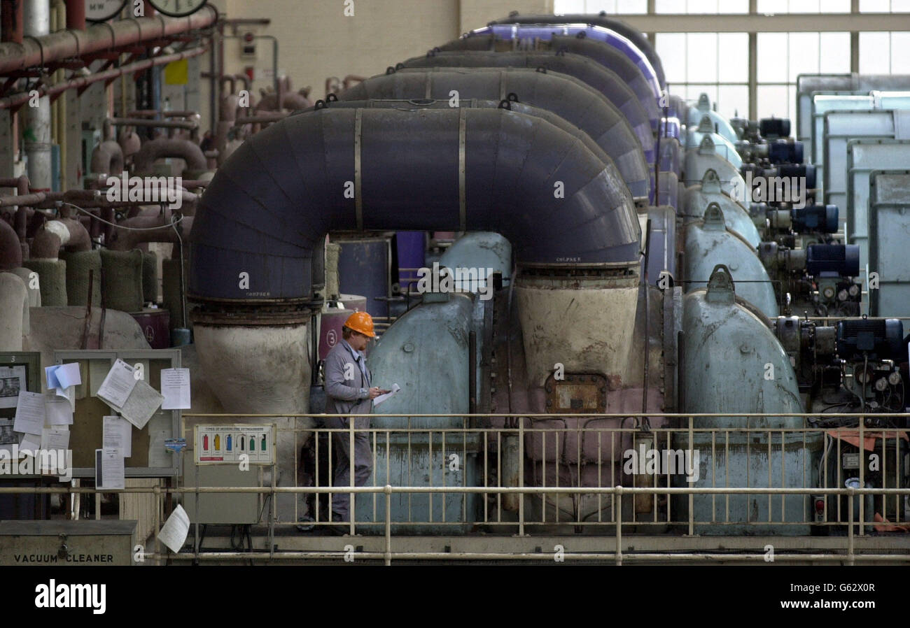 An Assistant Charge Engineer walks past a row of turbines in the main ...