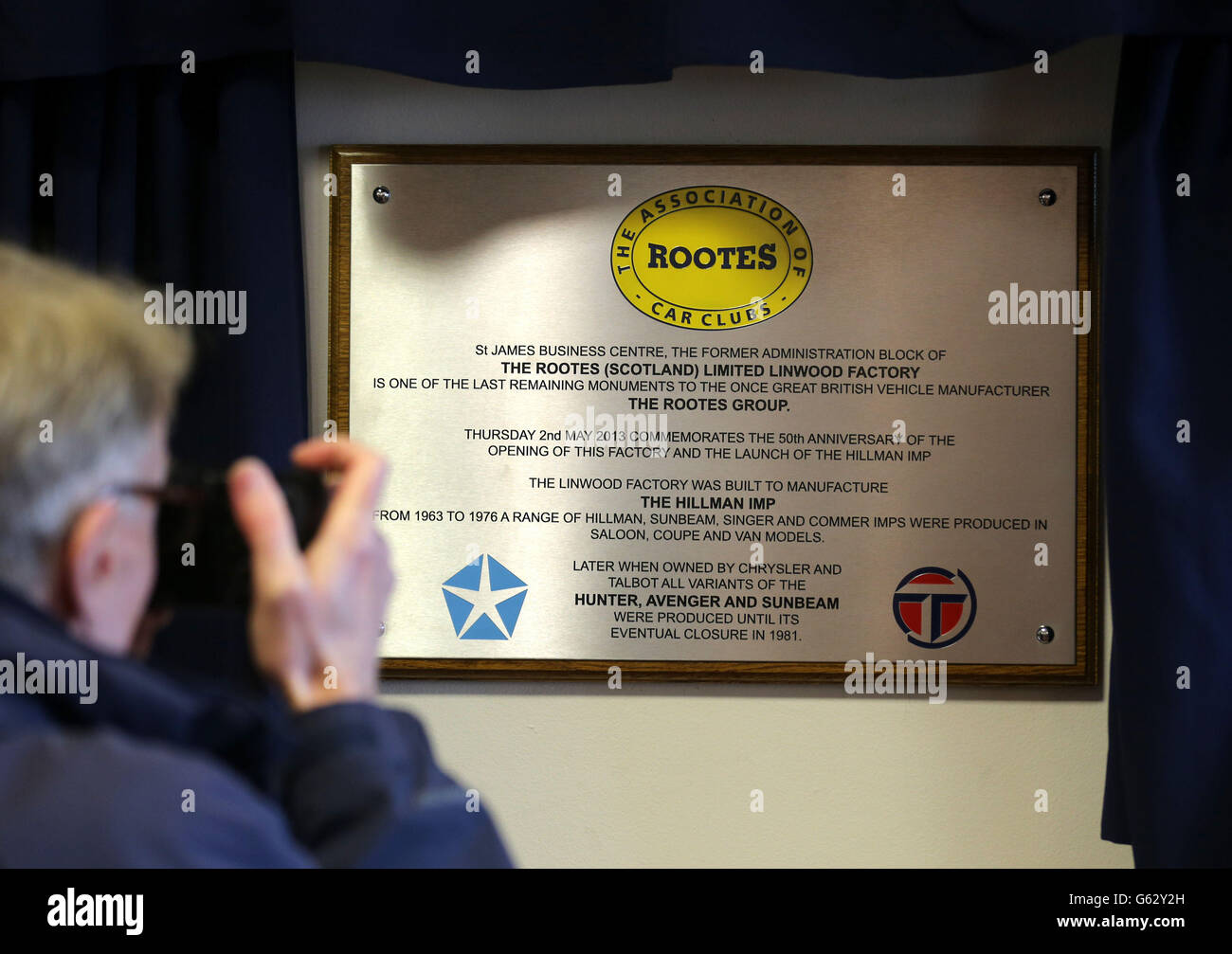 A man takes a picture of the plaque that was unveiled at the site of ...