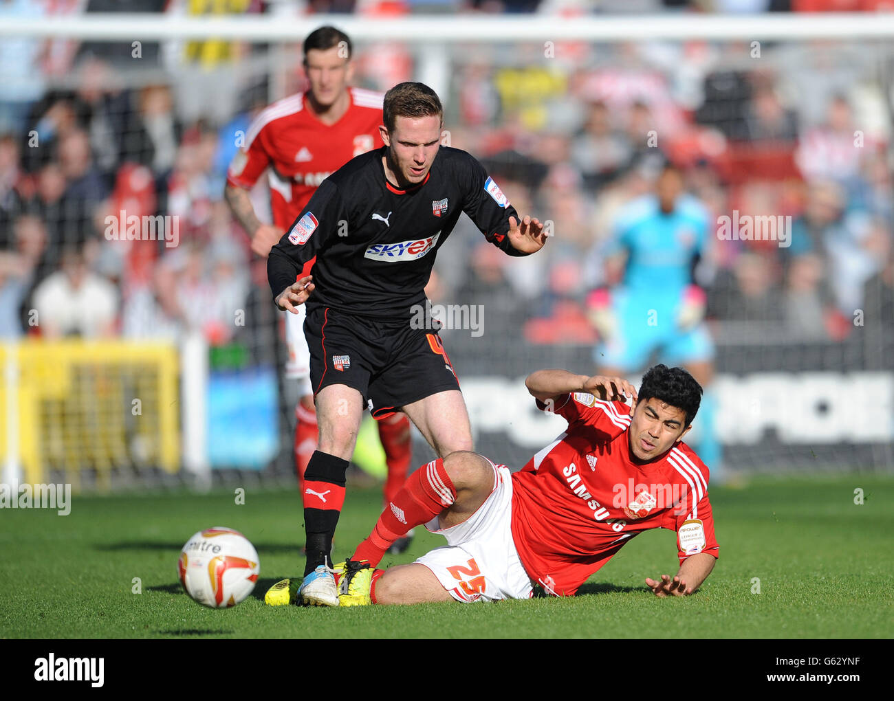 Swindon Town's Massimo Luongo slides in on Brentford's Adam Forshaw ...