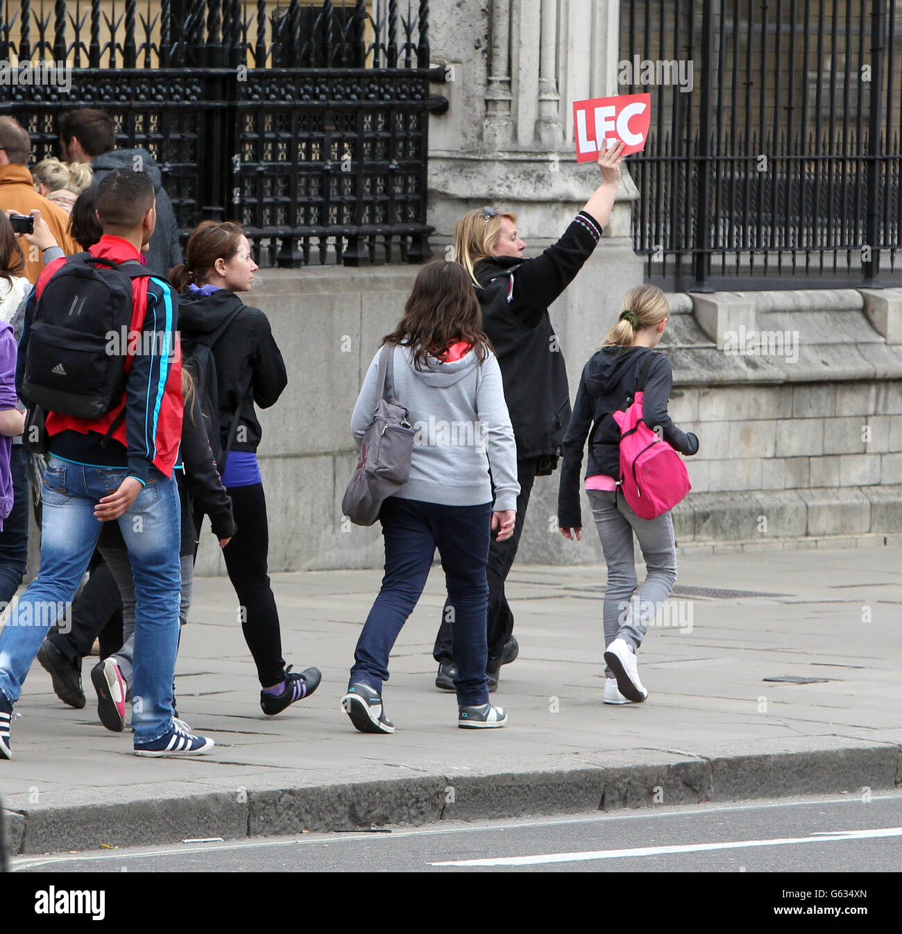 A Tour group passes the houses of Parliament in Central London Stock ...