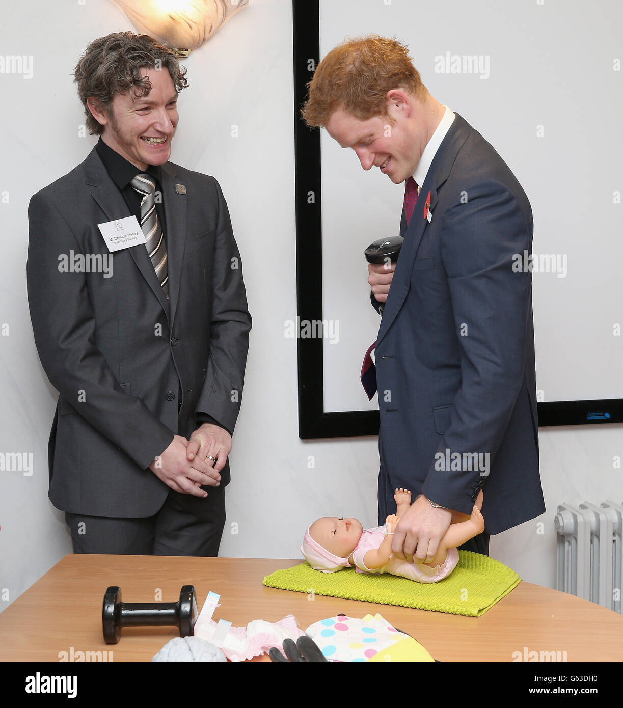 Prince Harry is watched by brain injury survivor Dominic Hurley as he ...