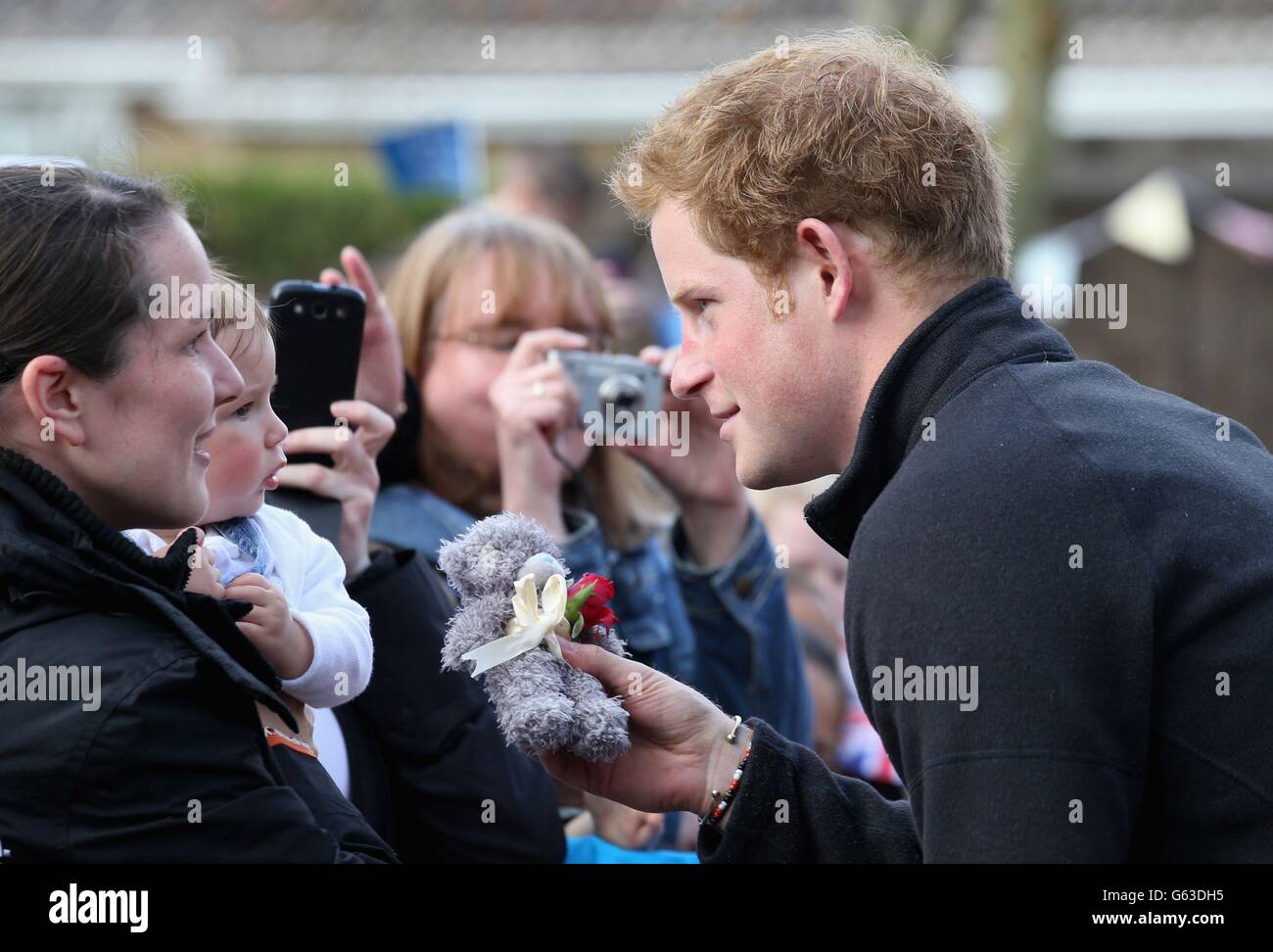 Prince Harry receives a teddy bear meets the public as he opens the new ...