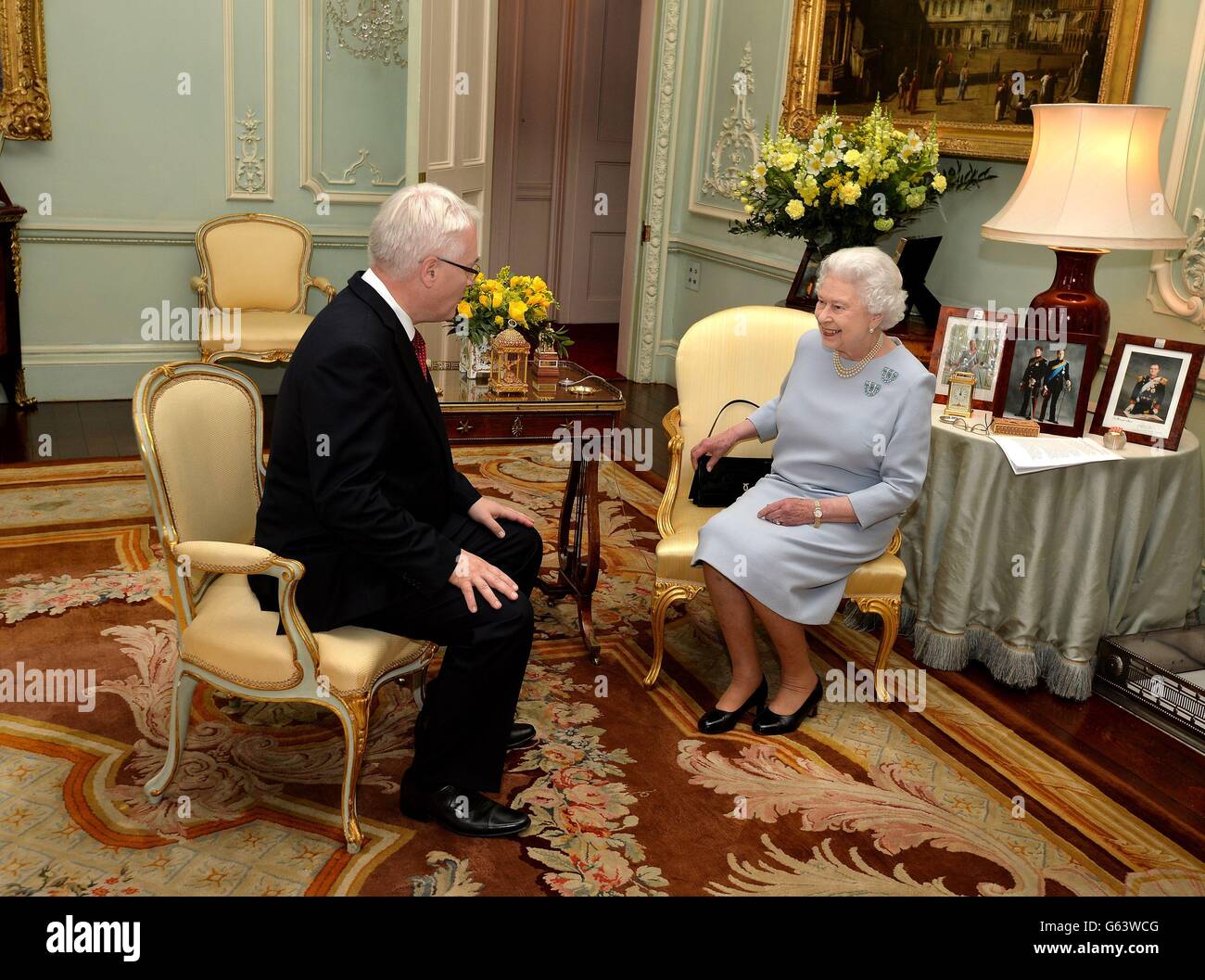 Who is in the framed picture on the table in this photograph of the ...