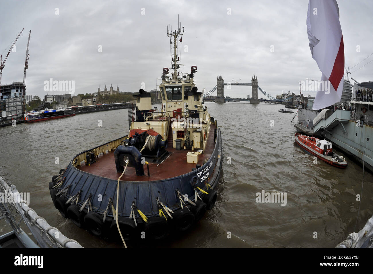 A view of Tower Bridge, London and a tug boat, which is ready to guide ...