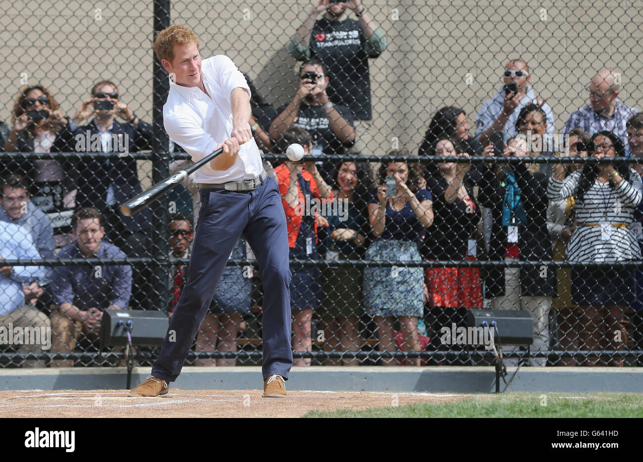 Prince Harry hits a baseball as he meets a number of young people ...
