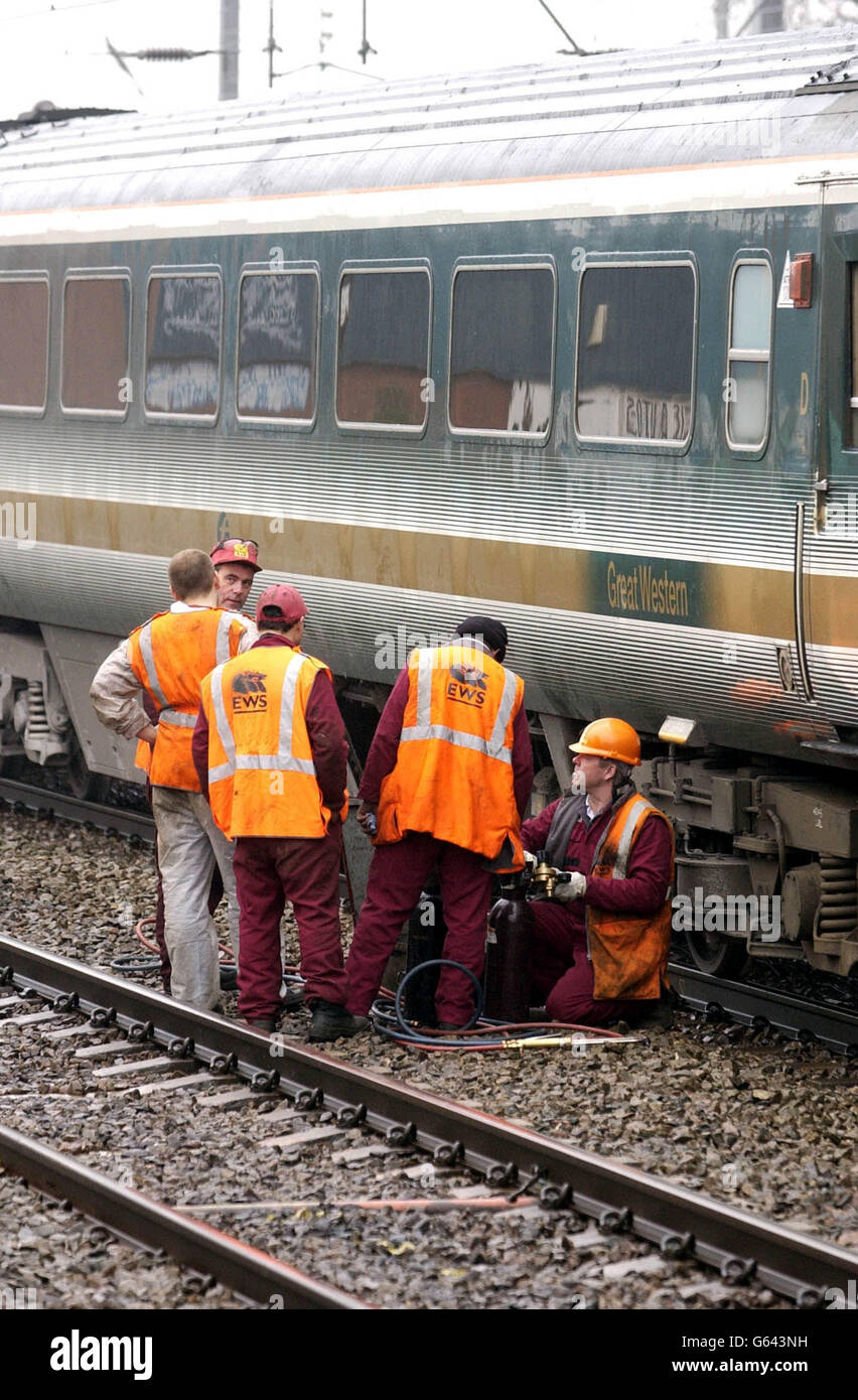 A derailed train sits stationary on the tracks as workers inspect the ...