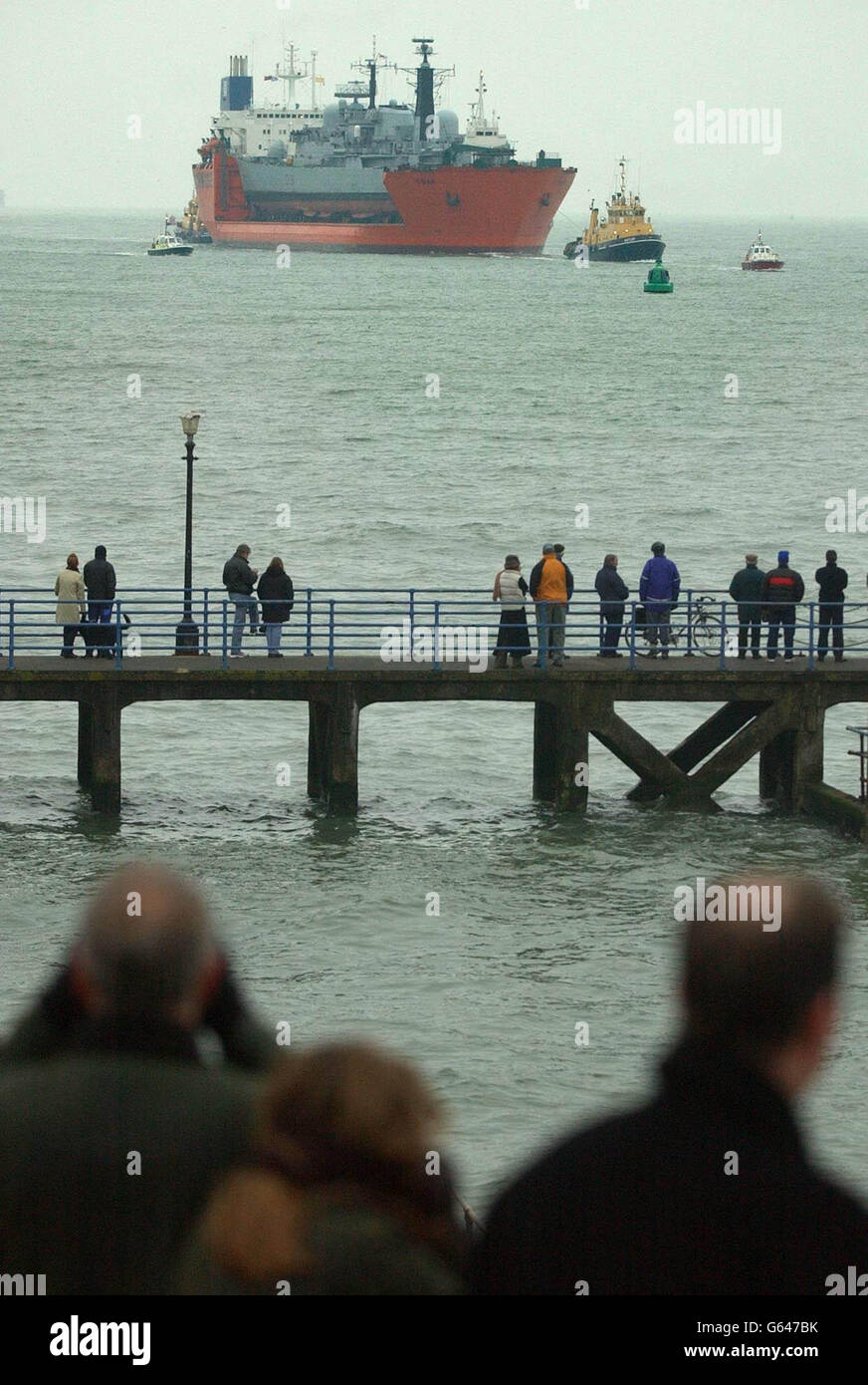 Onlookers watch the arrival of the Royal Navy ship HMS Nottingham on ...