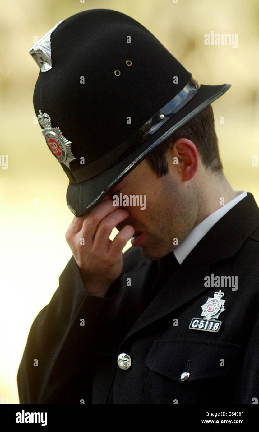 A Police officer shows emotion as the coffin of DC Stephen Oake arrives ...