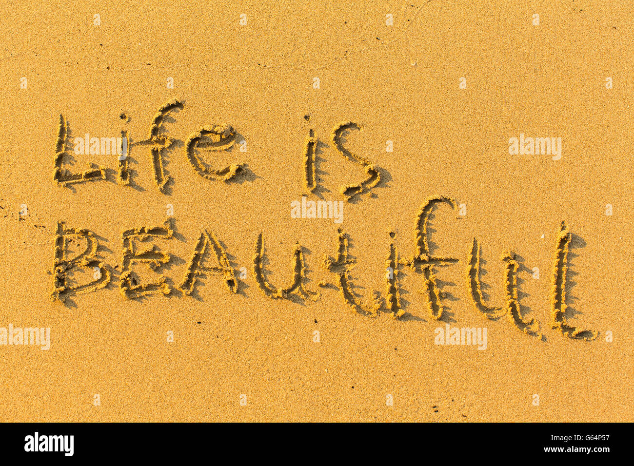 Life is beautiful - text drawn on the sand of beach Stock Photo - Alamy