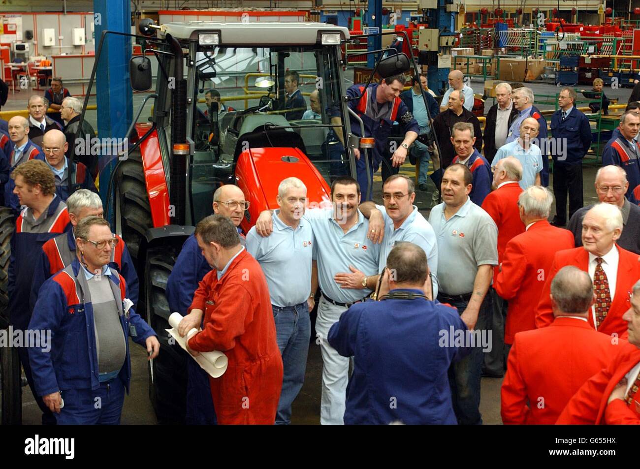 Workers gather around the 3,307,996th and final Massey Ferguson tractor ...