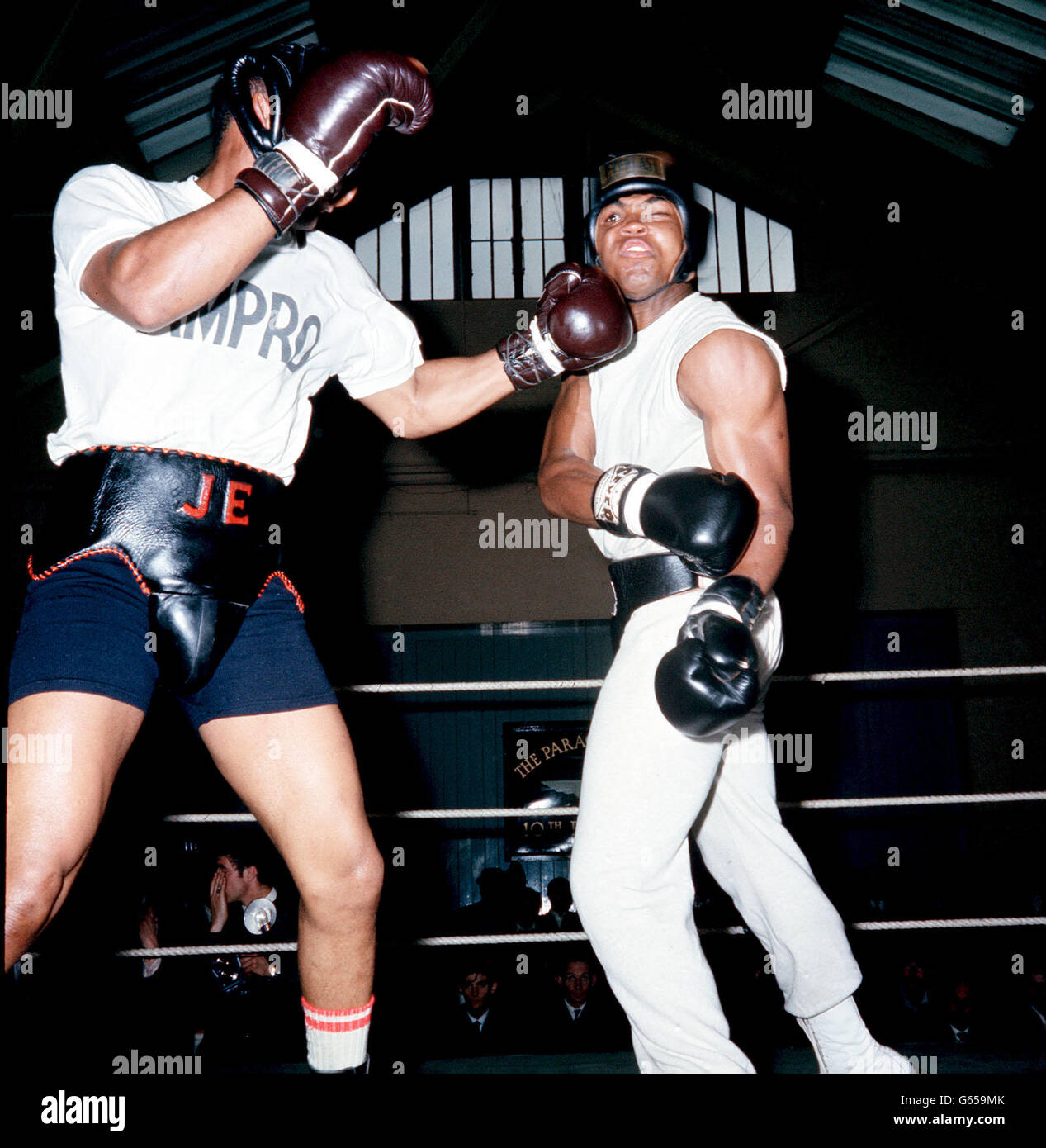 Clowning Cassius Clay takes a right from sparring partner Jimmy Ellis ...