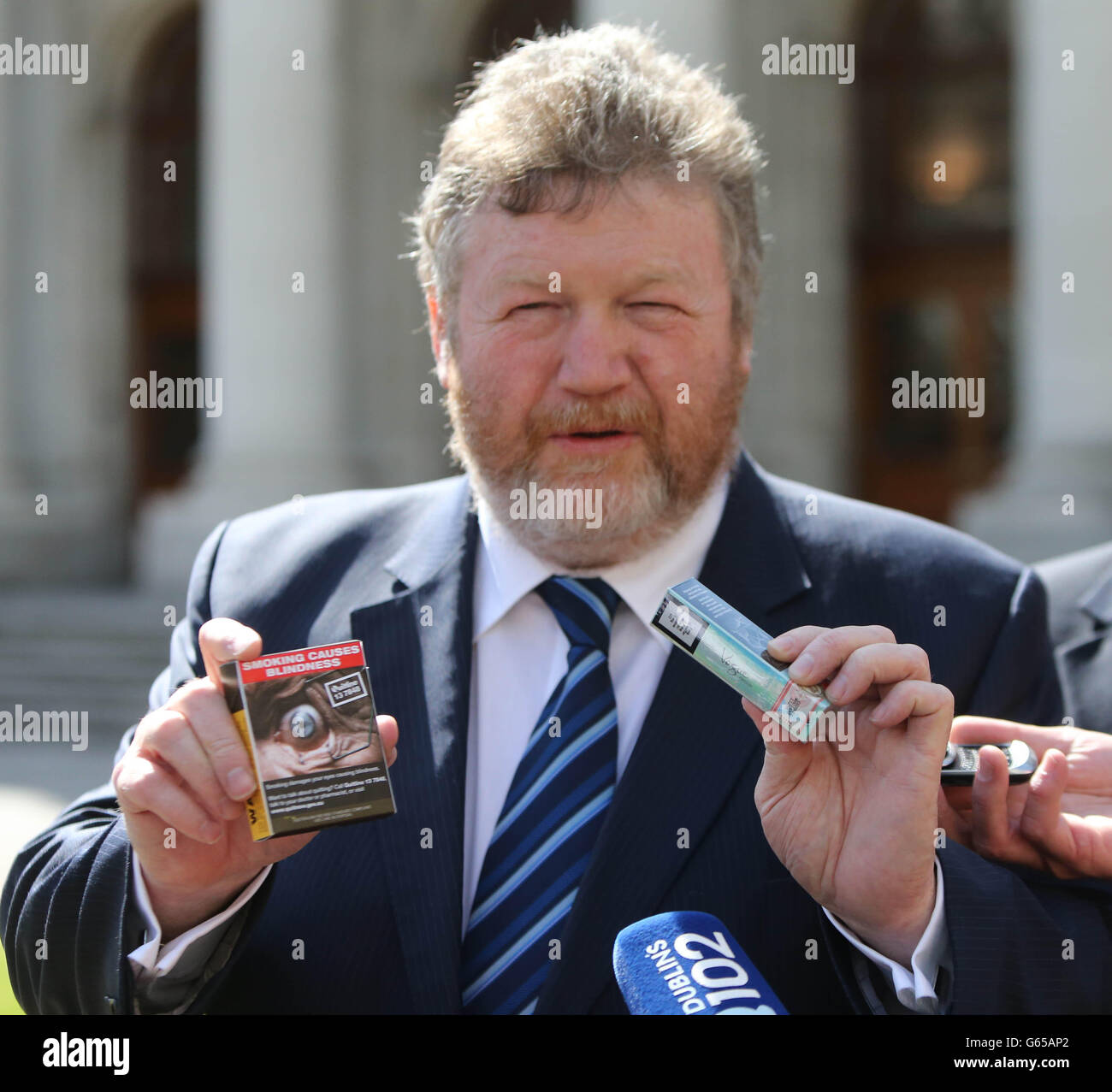 Irish Health Minister James Reilly holds examples of plain pack ...
