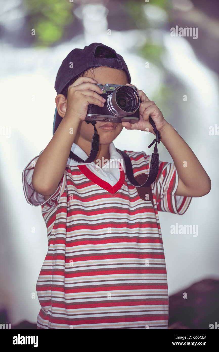 Asian child taking photo by professional digital camera on blurred ...