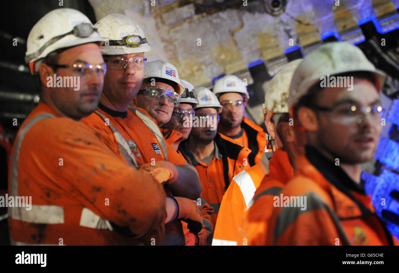 Construction workers watch as London Mayor Boris Johnson marks the ...