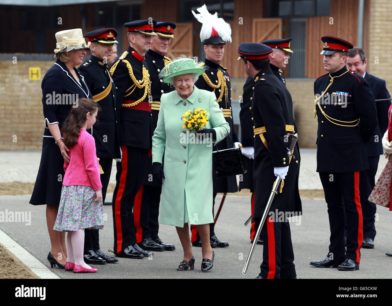 Queen Elizabeth II receives a bouquet from six year old Alice Edwards ...