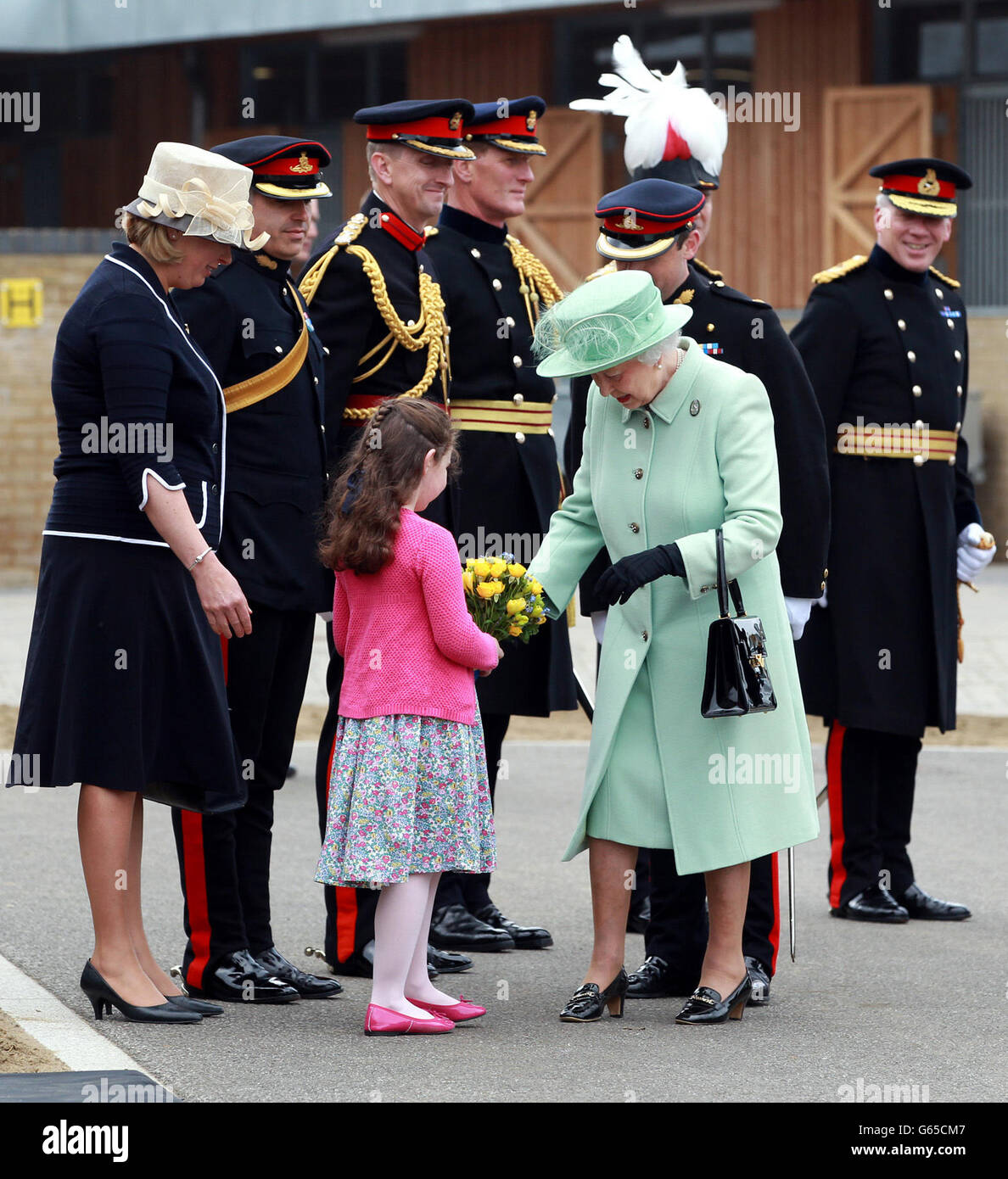 Queen Elizabeth II receives a bouquet from six year old Alice Edwards ...