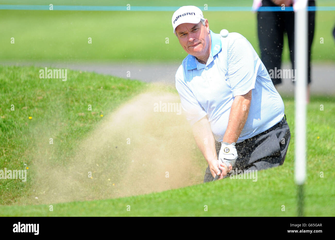 David Russell chips out of a bunker at the ninth green, during the ...