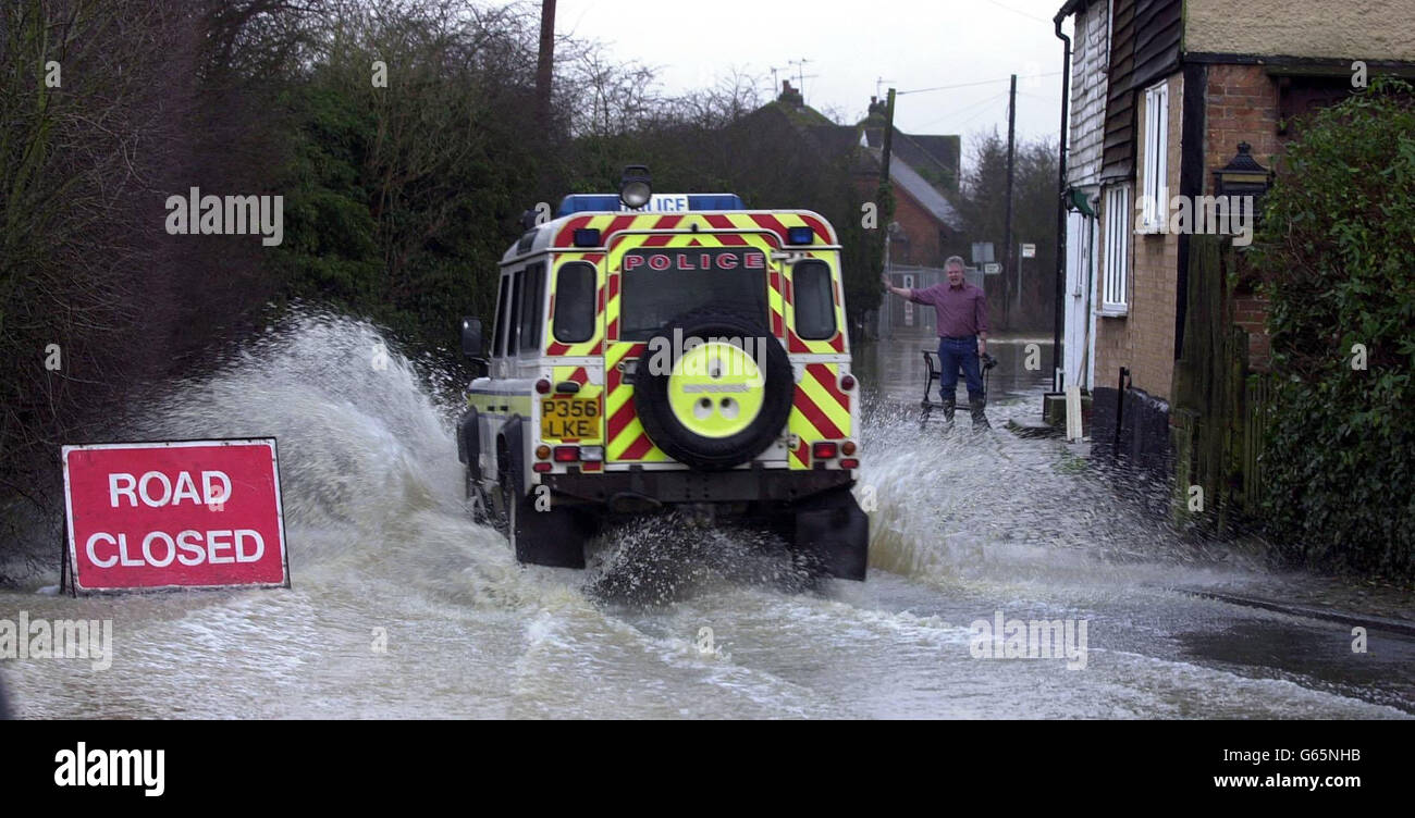 A Police Land Rover drives though a flooded road in the Kent village of ...