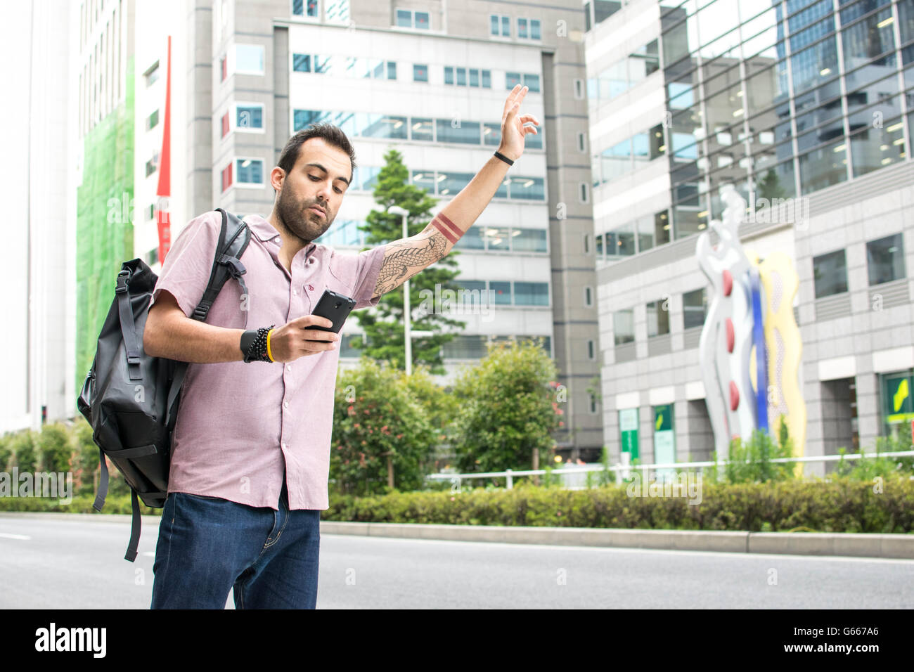 White man standing in road with cellphone hailing uber taxi Stock Photo ...