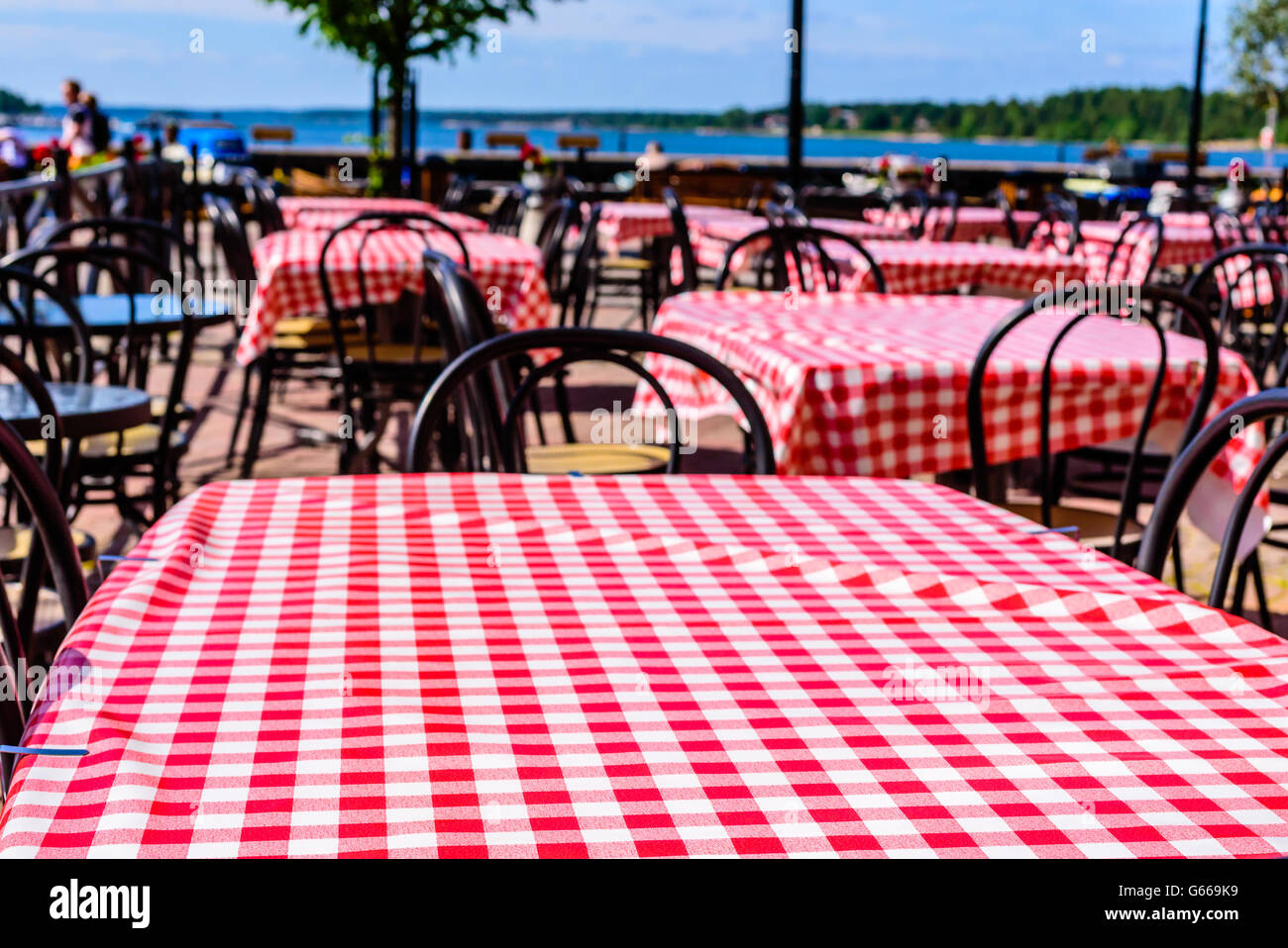 Red and white checkered table cloths at an outdoor eatery with ...