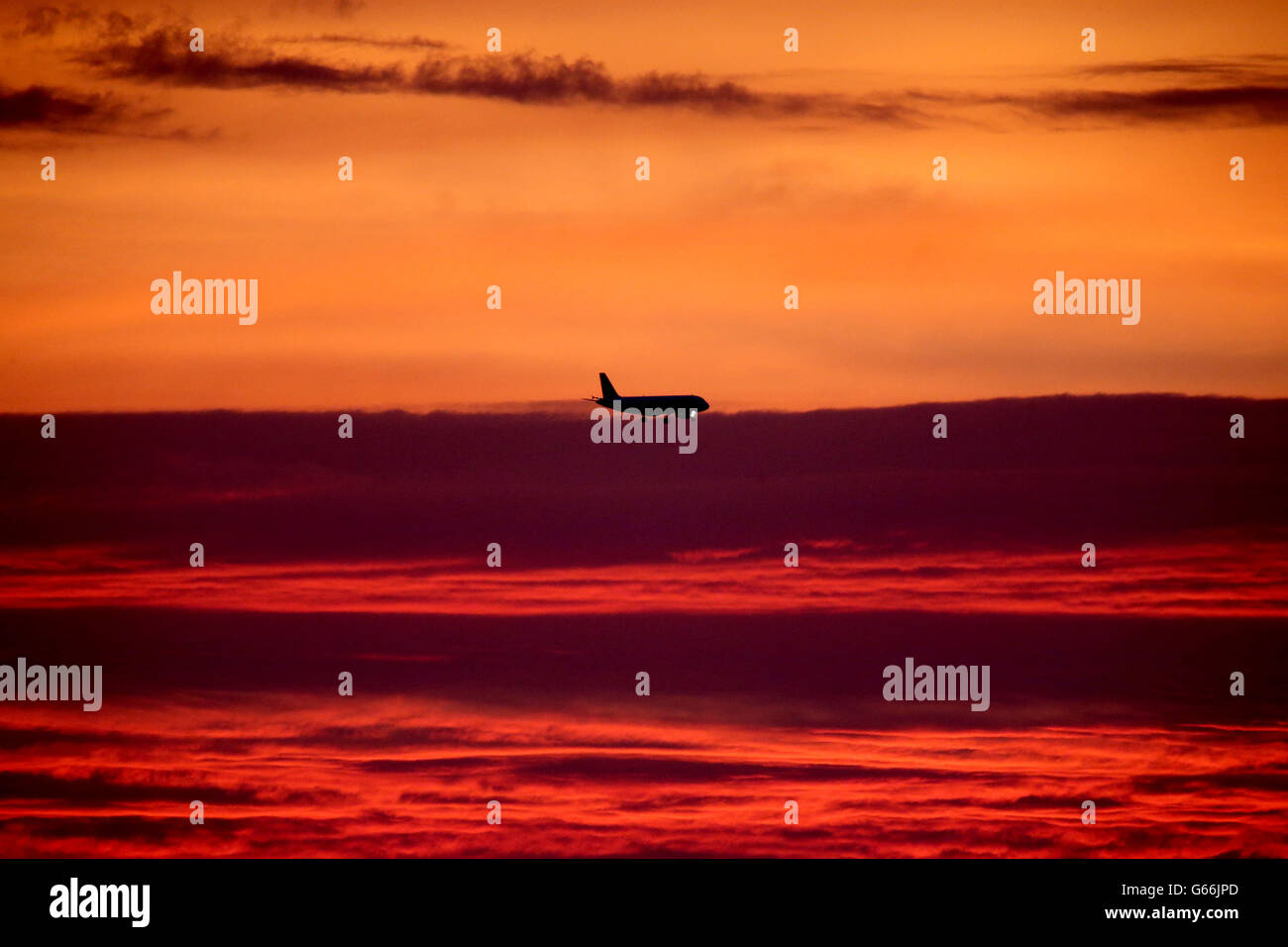 A plane leaves as the sunsets over heathrow airport hi-res stock ...