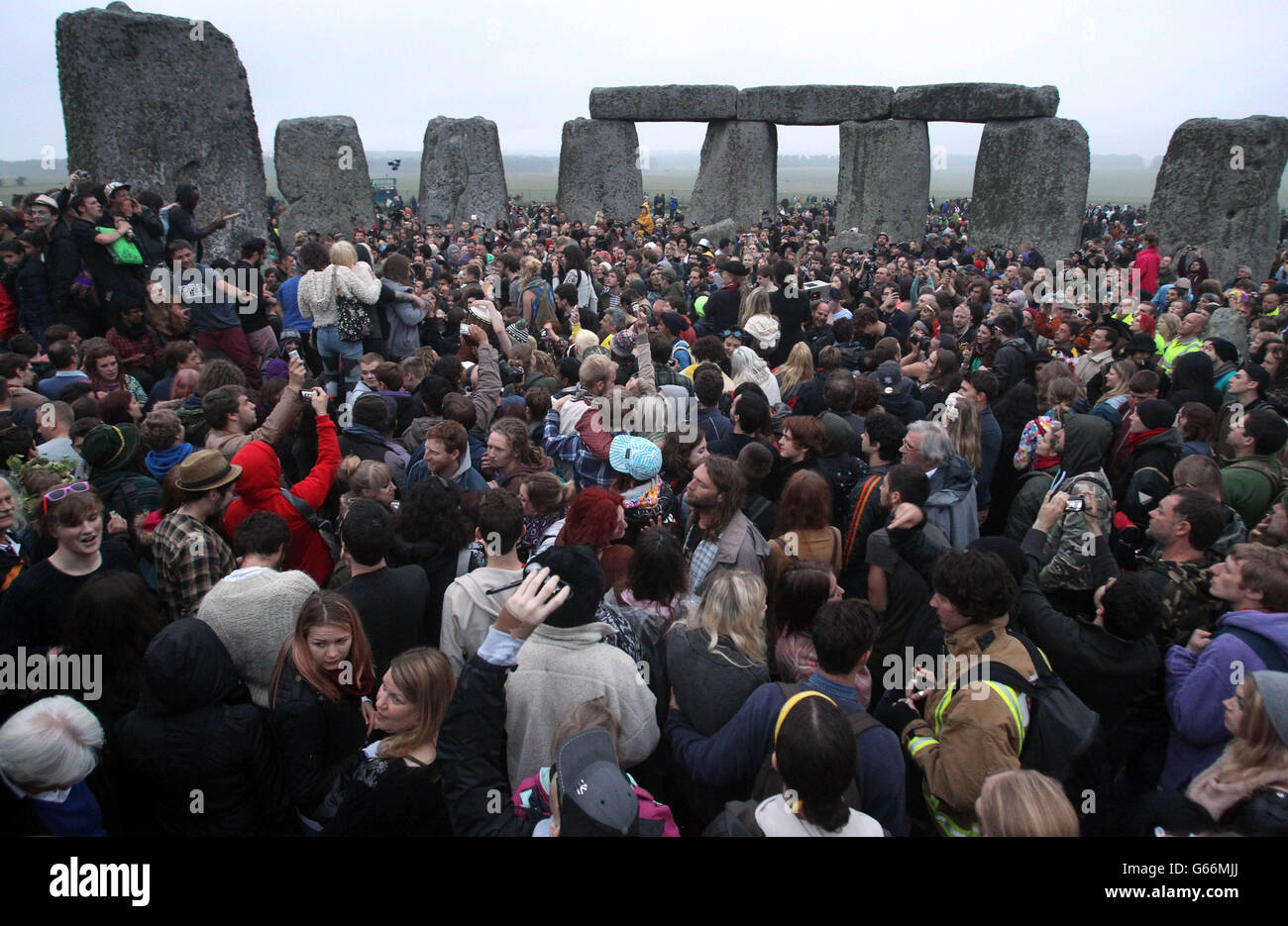 Summer Solstice at Stonehenge. Crowds gather at dawn amongst the stones ...