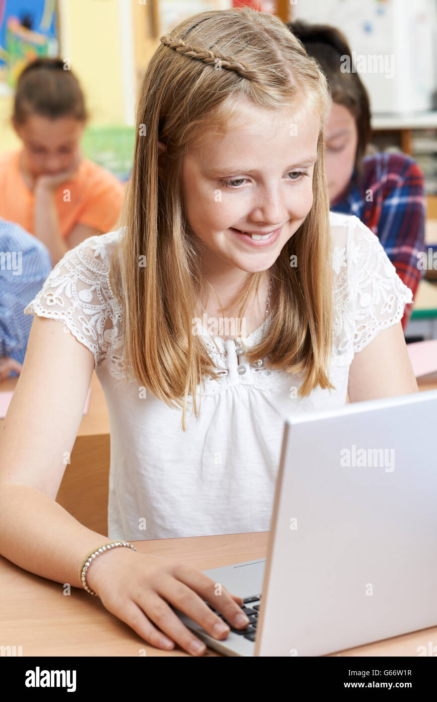 Female Elementary School Pupil Using Laptop In Computer Class Stock ...