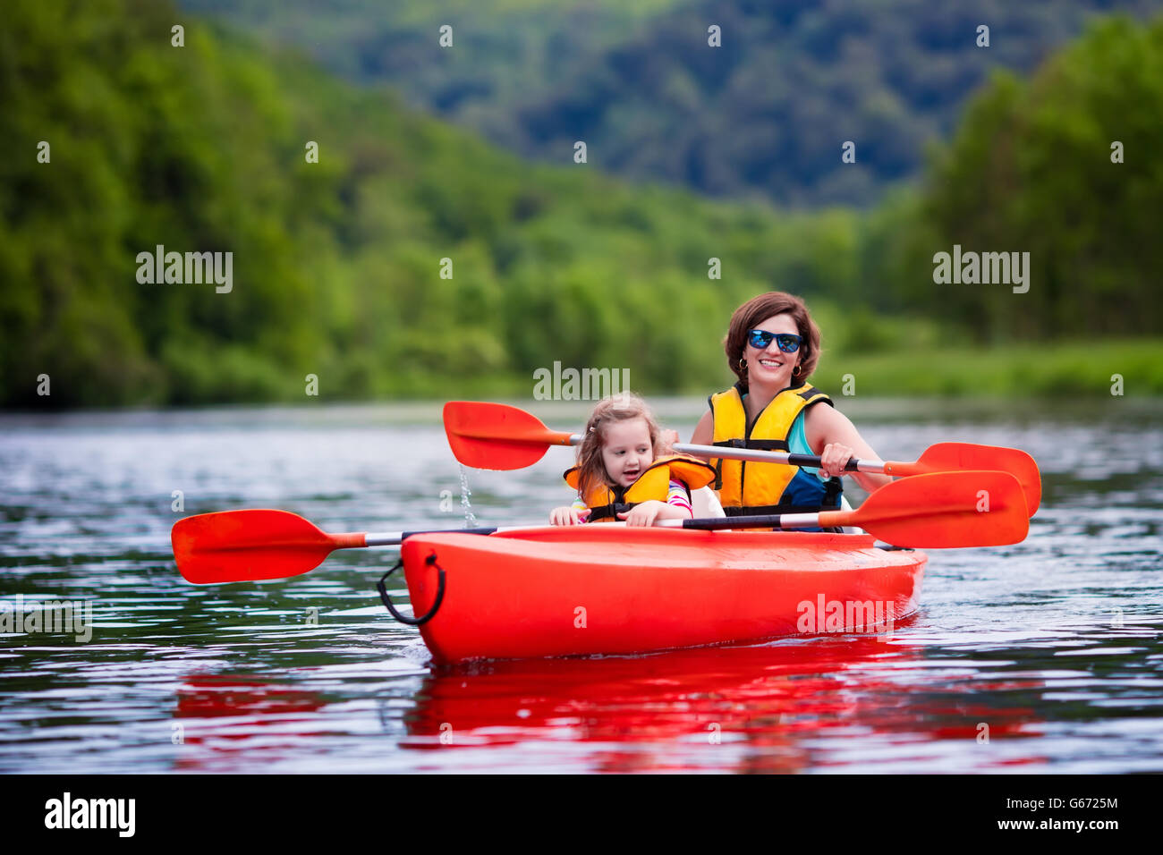 Family on kayaks and canoe tour. Mother and child paddling in kayak in ...