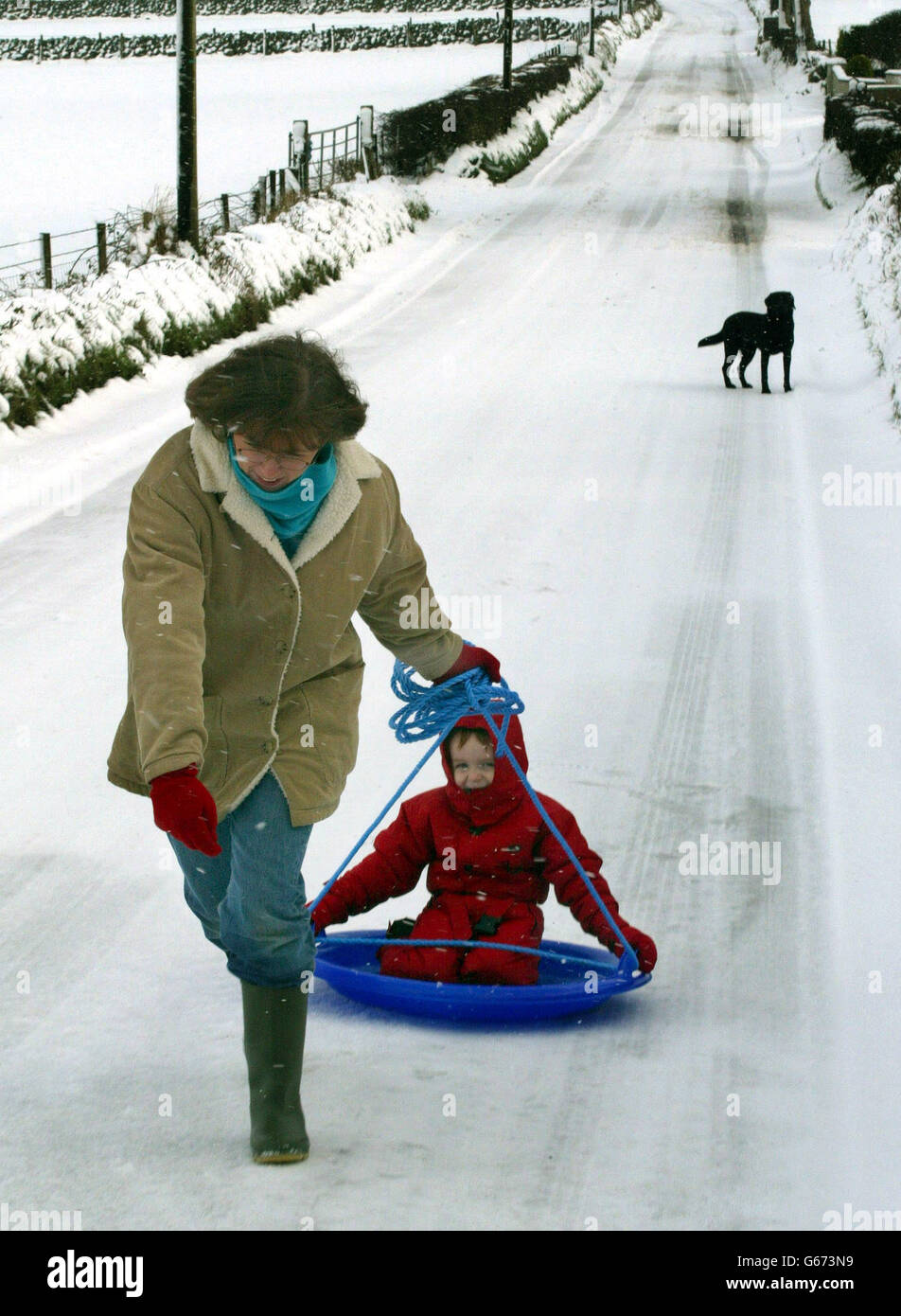Daniel Faith, aged 4, is pulled in his sledge by his mum Margaret, in ...