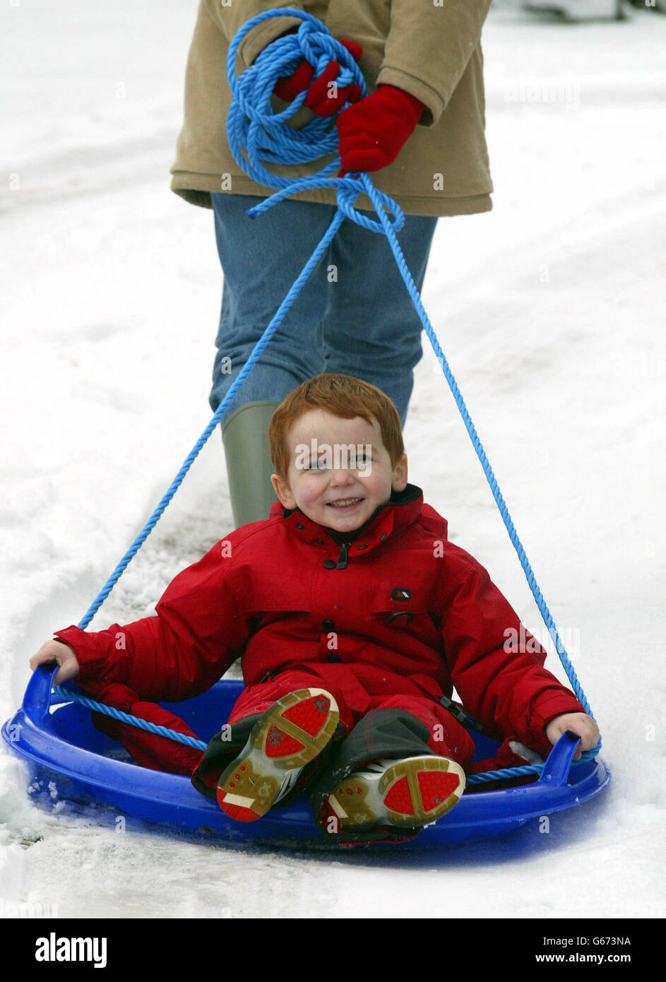 Daniel Faith, aged 4, is pulled in his sledge by his mum Margaret, in ...