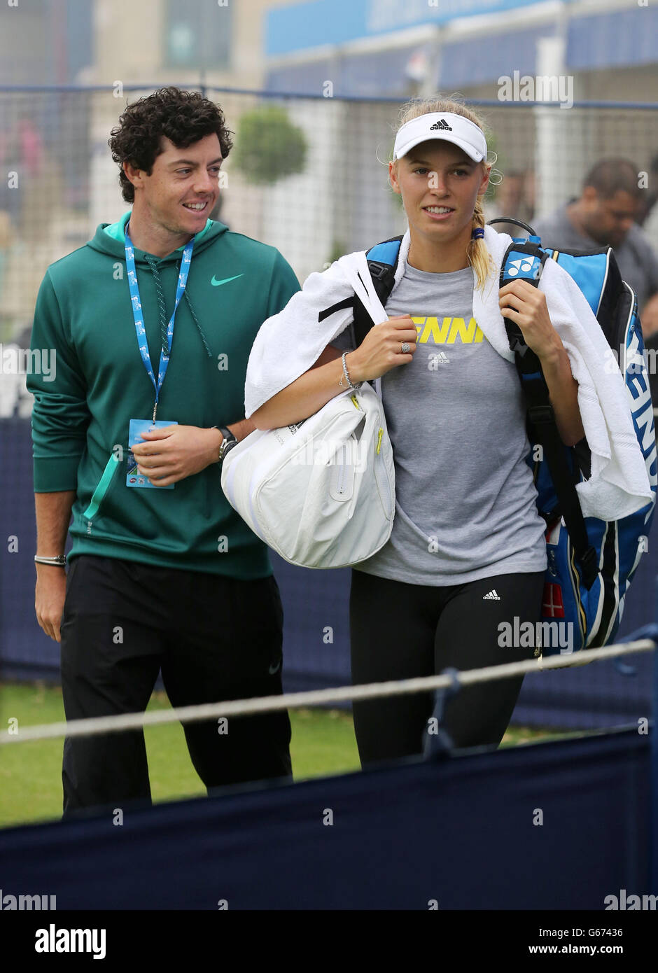 Golfer Rory McIlroy walks off the practice courts with his girlfriend ...