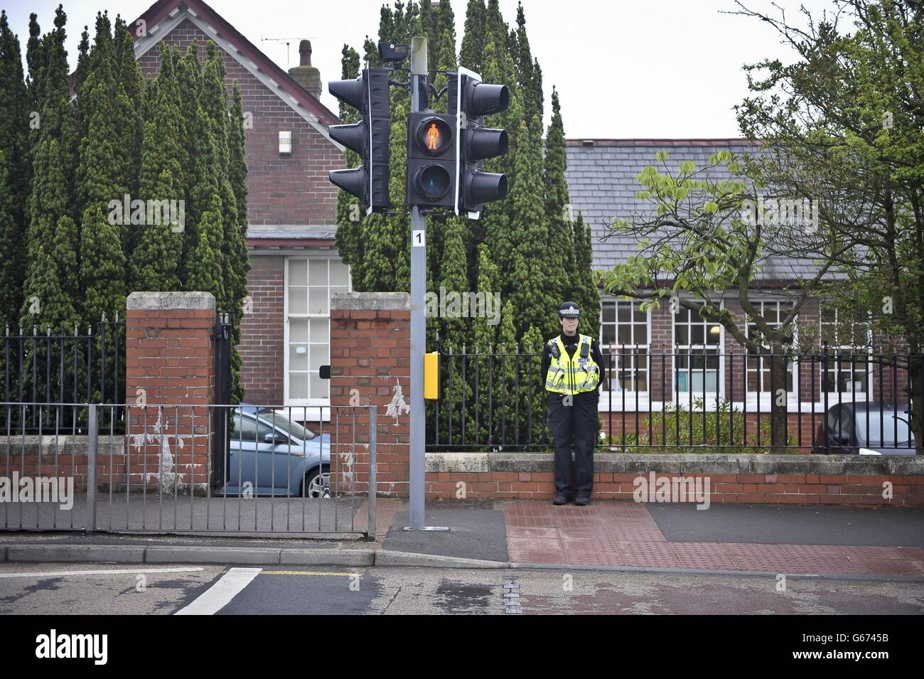 A police officer stands outside Rhoose Primary School in Rhoose, Wales ...